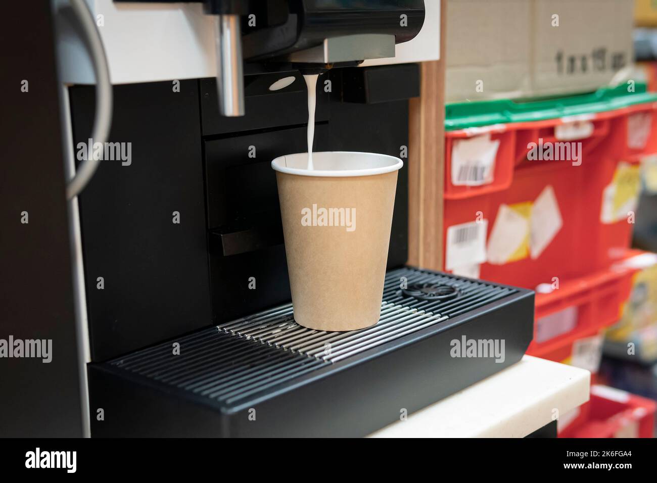 prepares espresso. coffee machine pours hot coffee into a cardboard cup ...