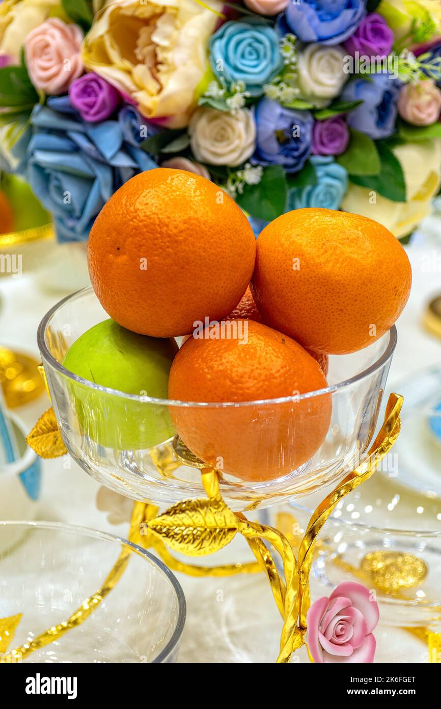 Fresh fruits in glass vase on festively decorated table Stock Photo - Alamy