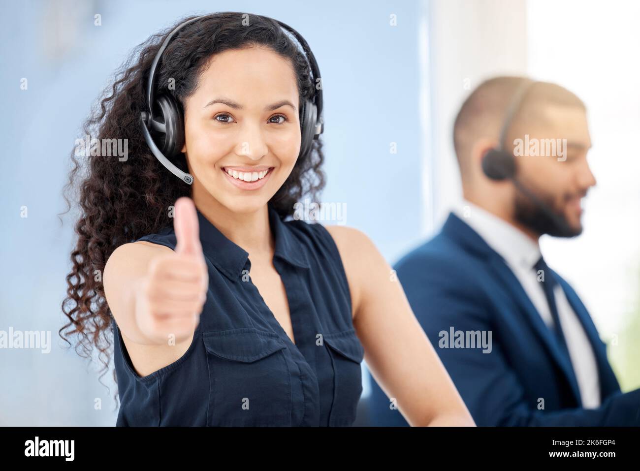 Its a thumbs up for me. a young female call center agent showing a ...