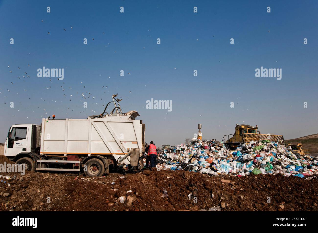 Municipal waste landfill. Workers with trucks and bulldozers at work in ...
