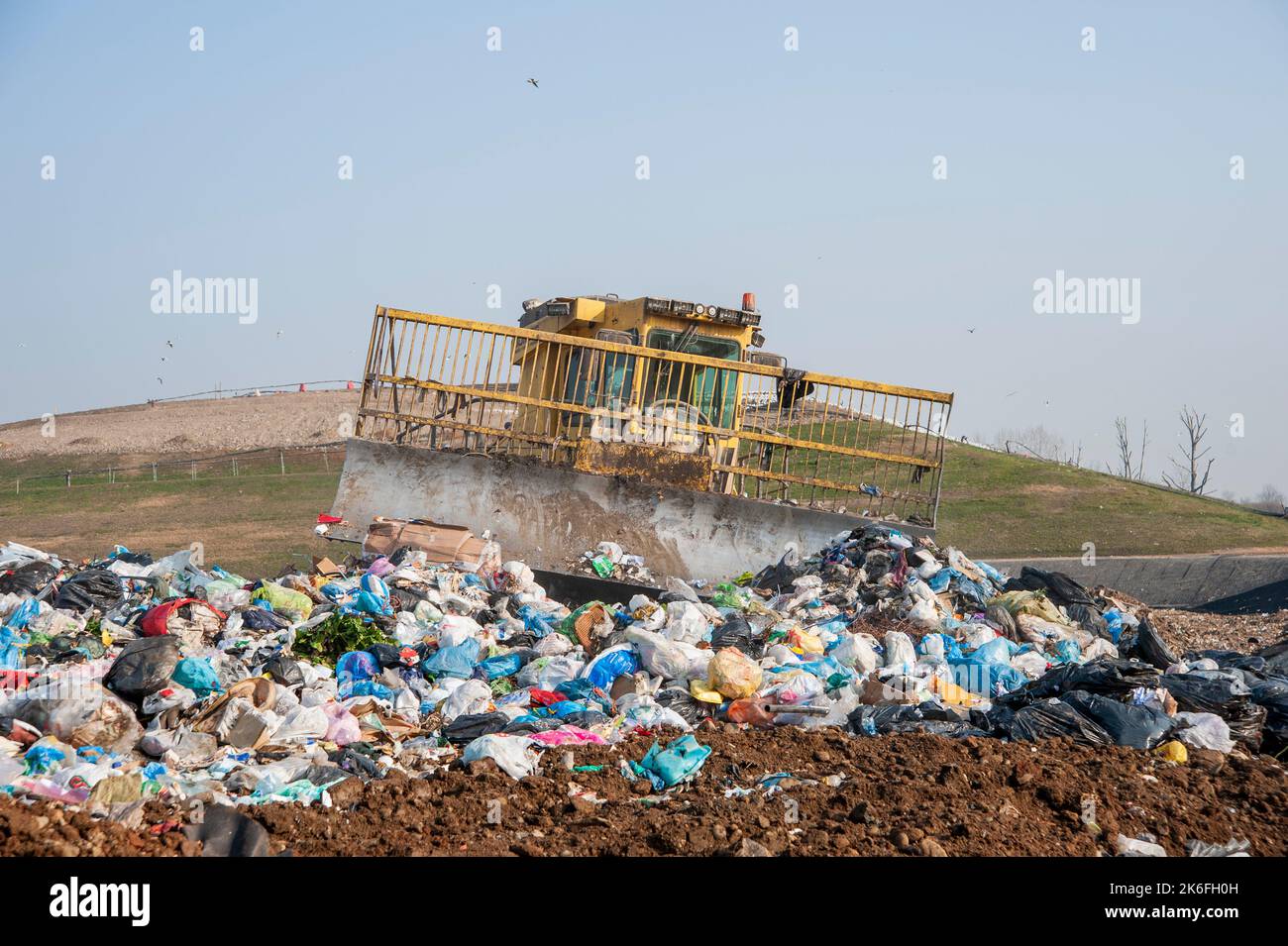 Municipal waste landfill. Workers with trucks and bulldozers at work in ...