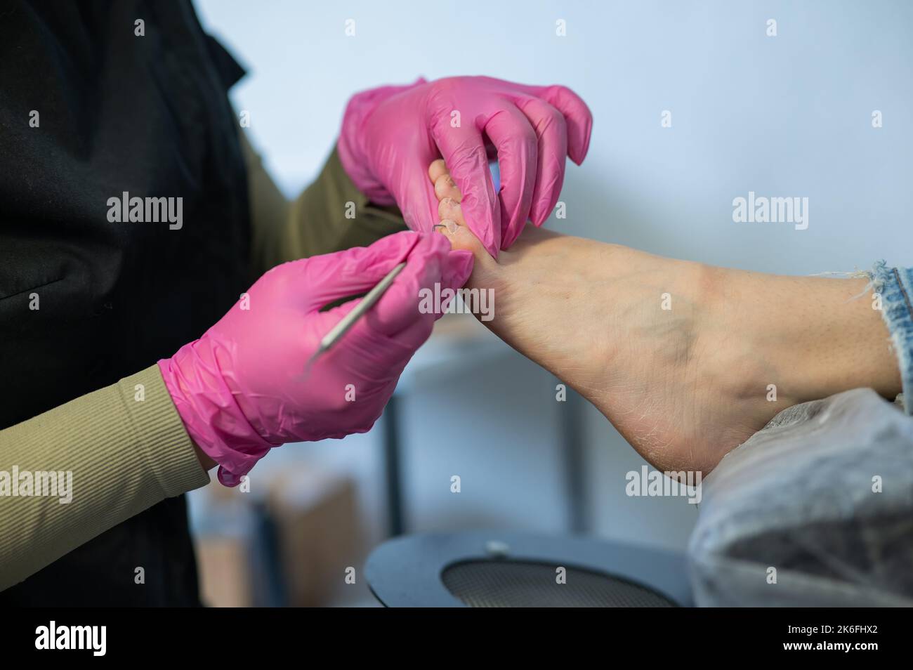 Podiatrist makes a pedicure to a client. The master conducts hygiene of ...