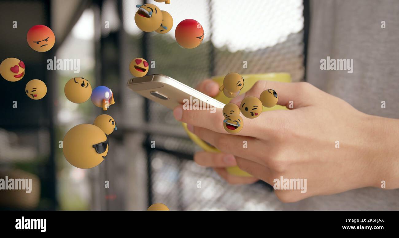 Image of emoticons over hands of caucasian woman with smartphone ...