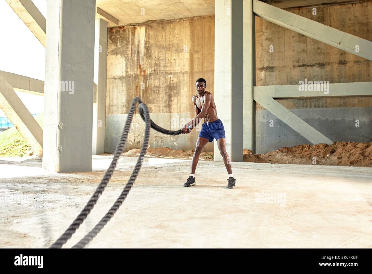 Rope workout. Sport man doing battle ropes exercise outdoor. Black male ...