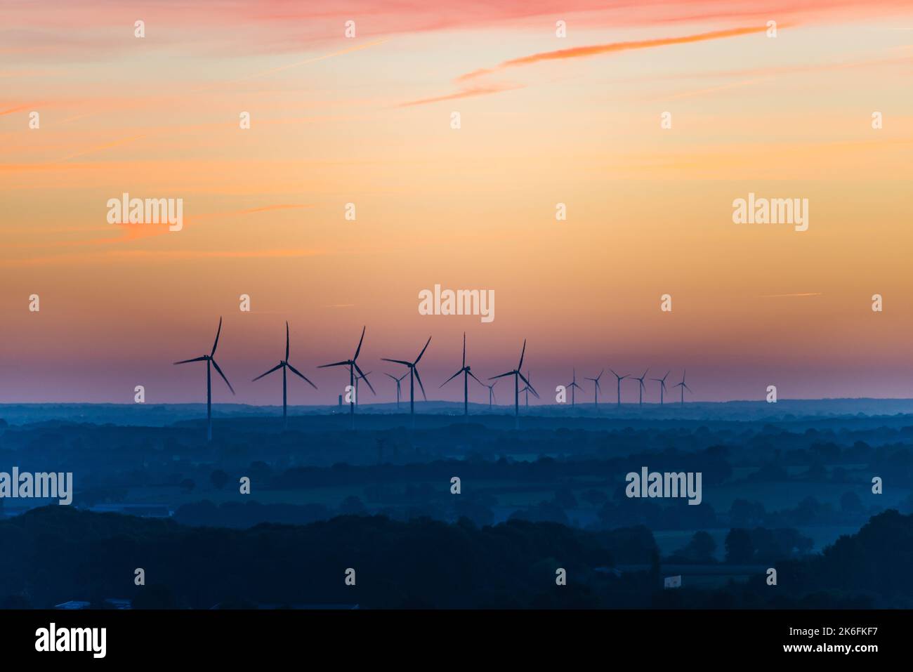 Postcard panorama. View of a wind farm at sunrise. Renewable energies ...
