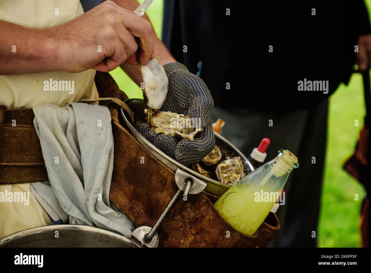 closeup of the hand of a man with a chainmail glove chucking an oyster ...