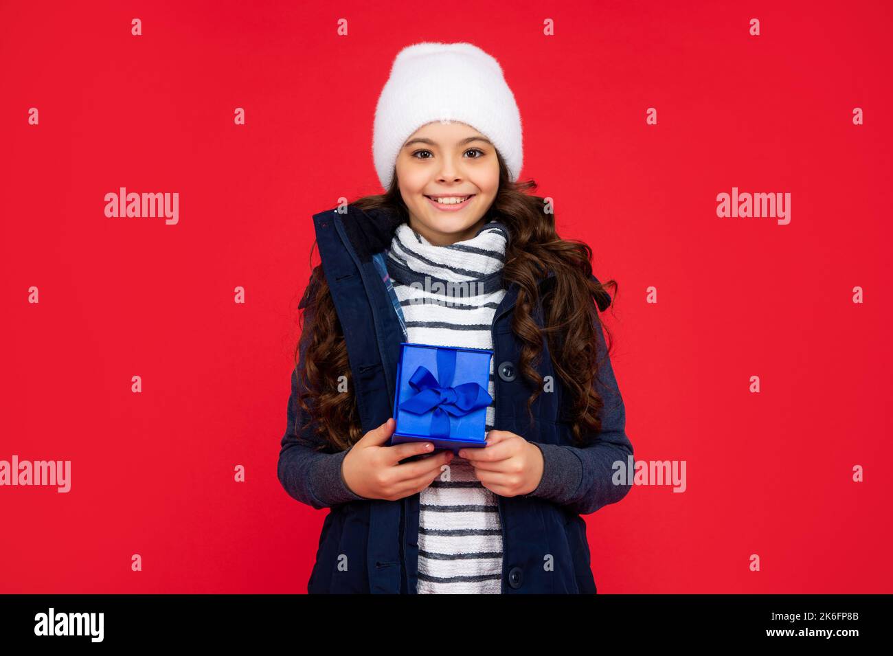 happy child in puffer jacket and hat hold box. kid with present. teen ...