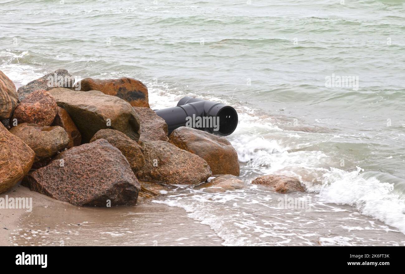 Black pipe with water poured into sea, beach pollution - Tourist ...