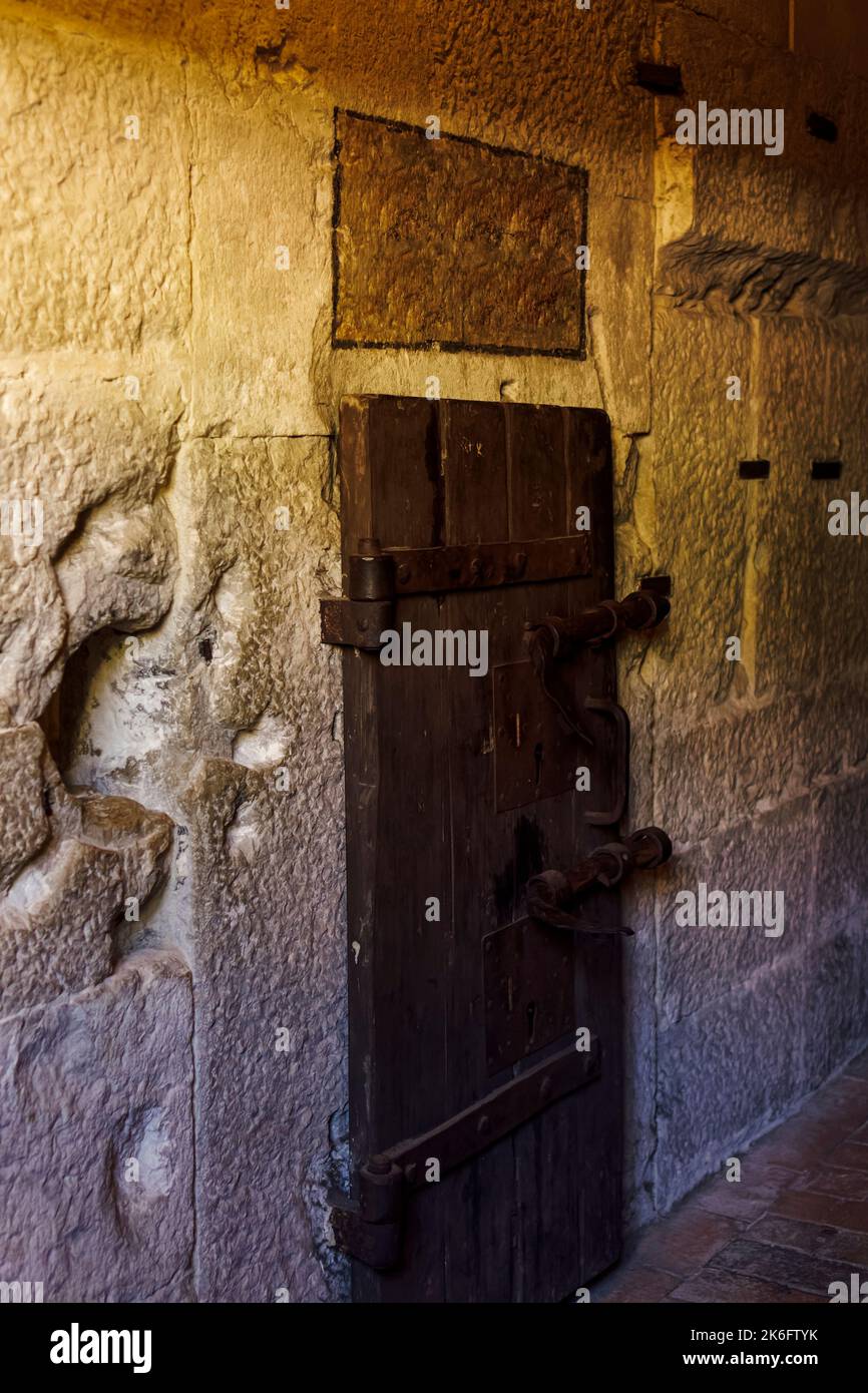 Dungeon cell locked old wooden door around a stone wall Stock Photo - Alamy