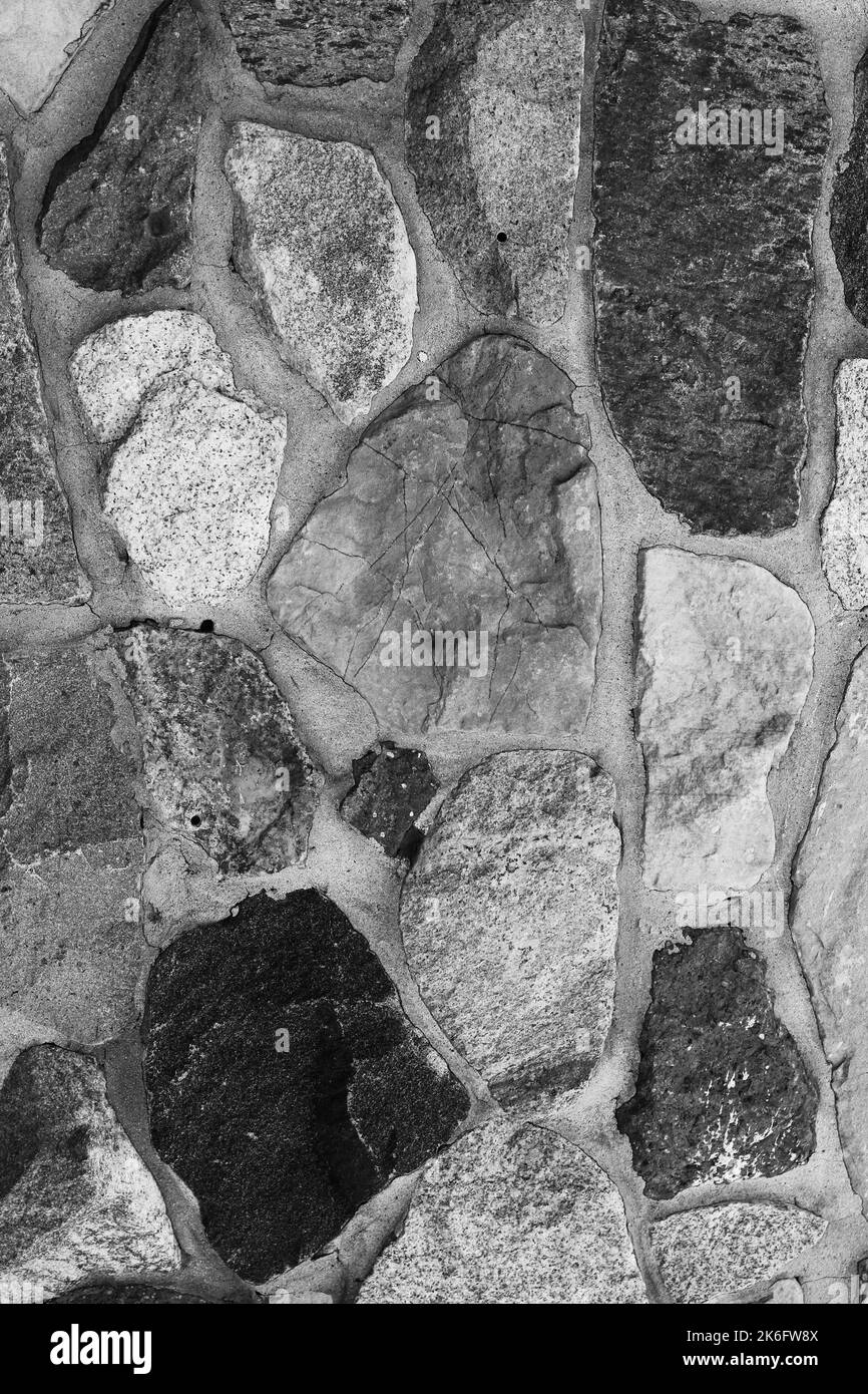 Natural stone wall made with a random pattern in a black and white ...