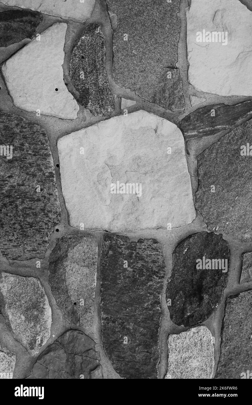 Natural stone wall made with a random pattern in a black and white ...