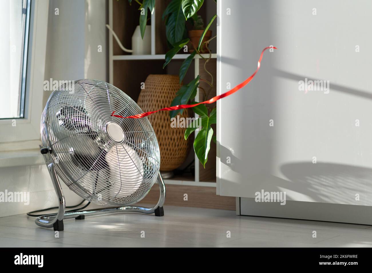 Electric fan with red wriggle ribbon designed to cool air and supply ...