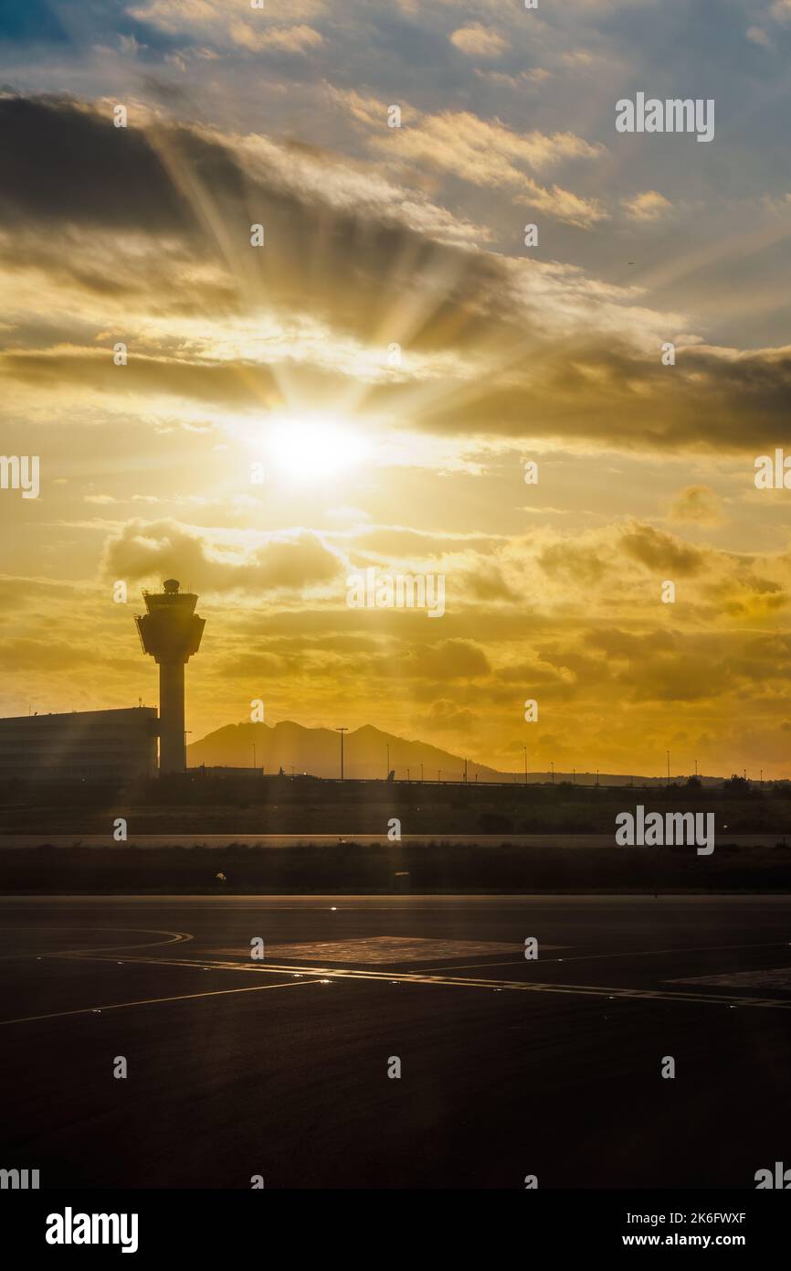 Day view of empty runway with airport tower control silhouette and ...