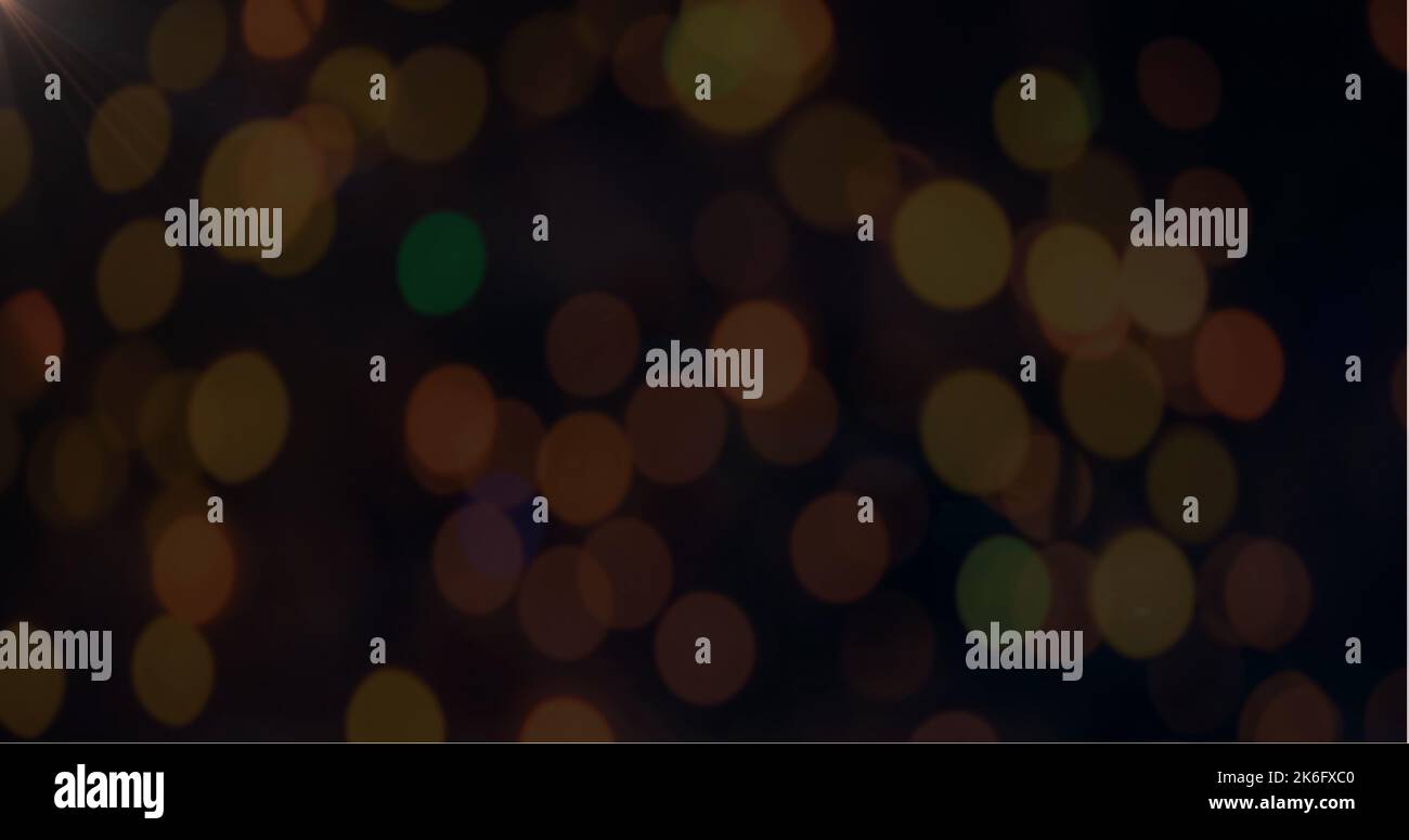 Full frame shot of illuminated lens flares against black background ...
