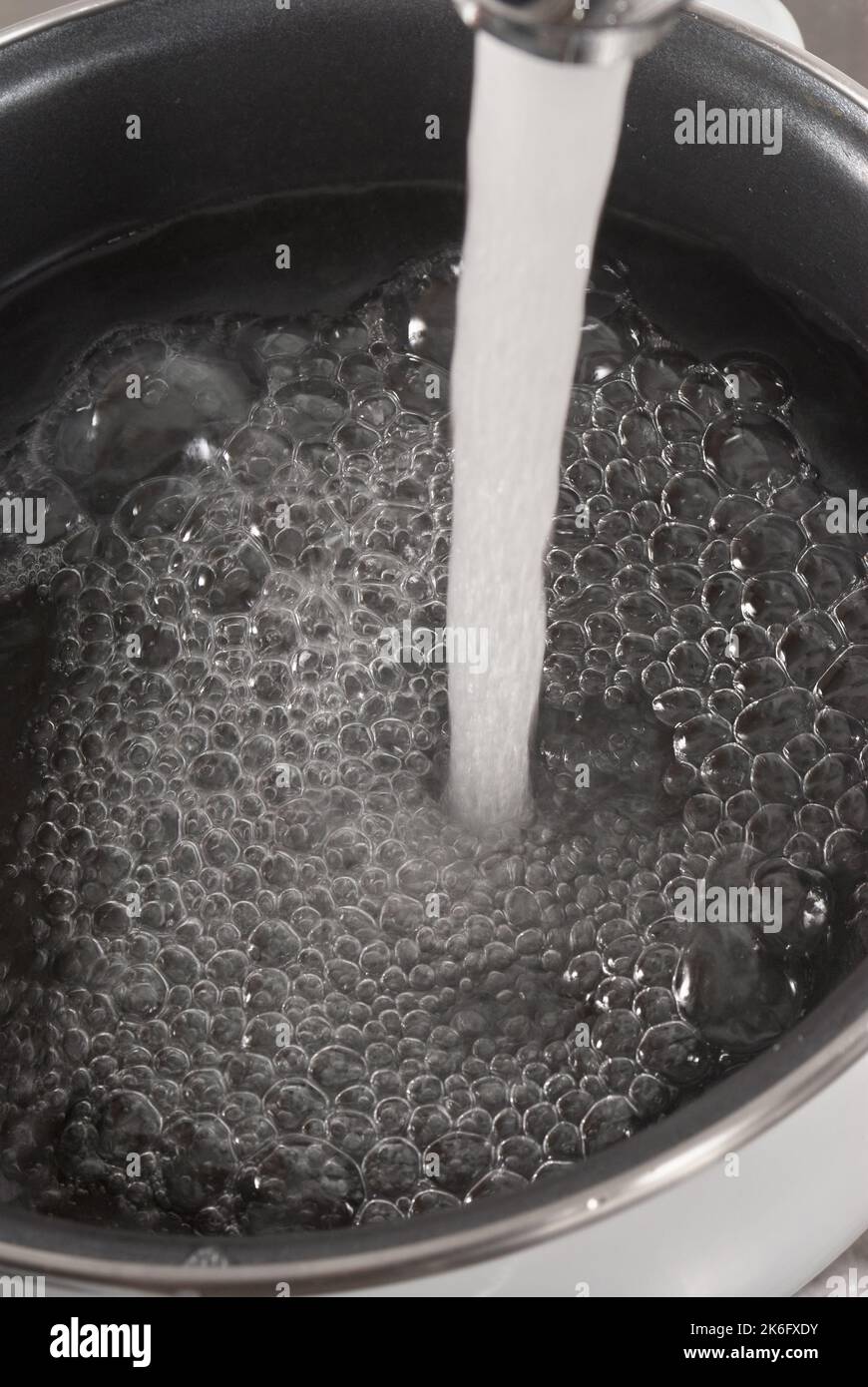 Jet of water falling into a pot creating bubbles Stock Photo - Alamy
