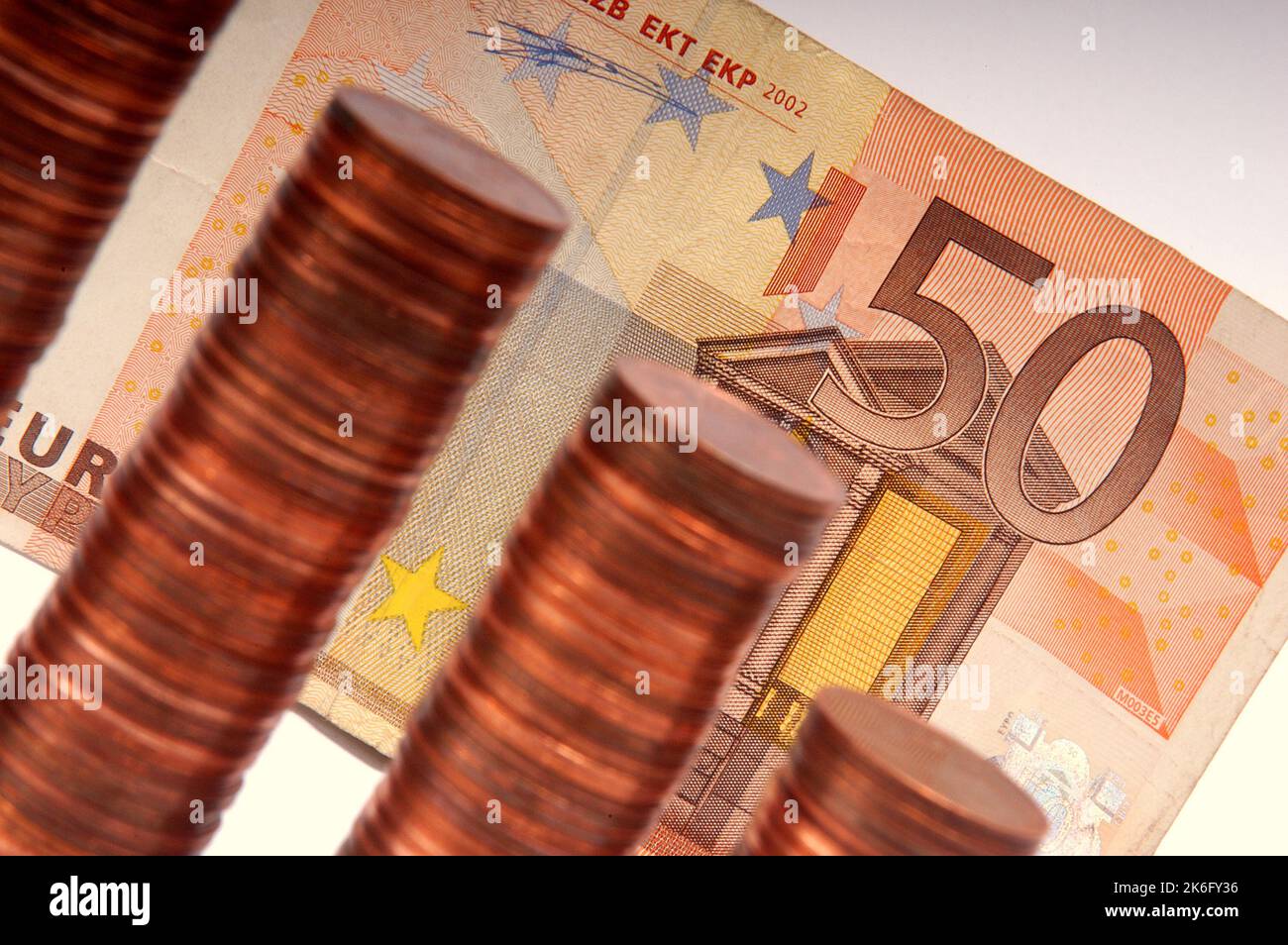 Pile of euro coins in front of a bill Stock Photo - Alamy