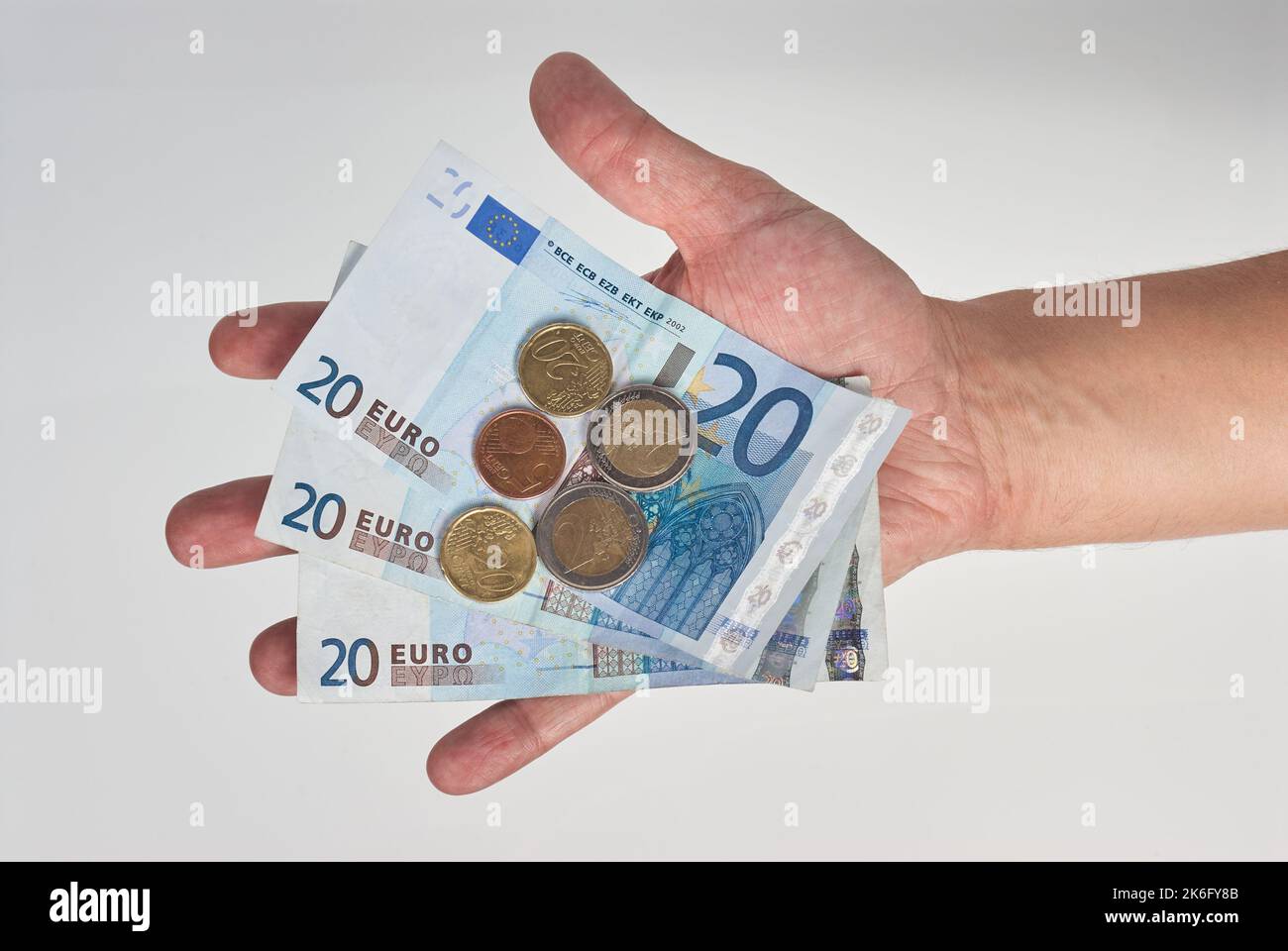 Hand with different coins and euro bills Stock Photo - Alamy