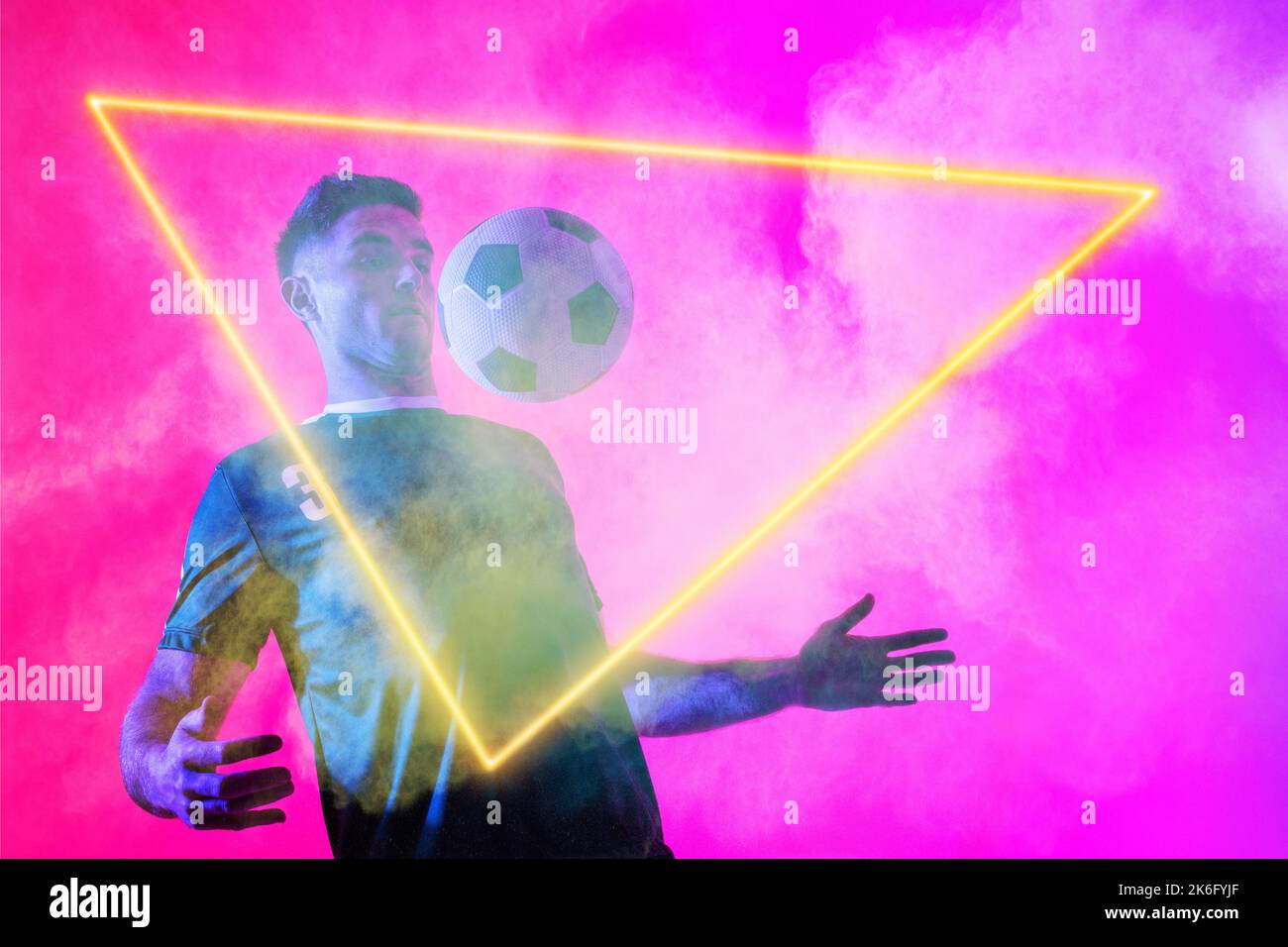 Male caucasian player juggling with ball on chest over illuminated ...