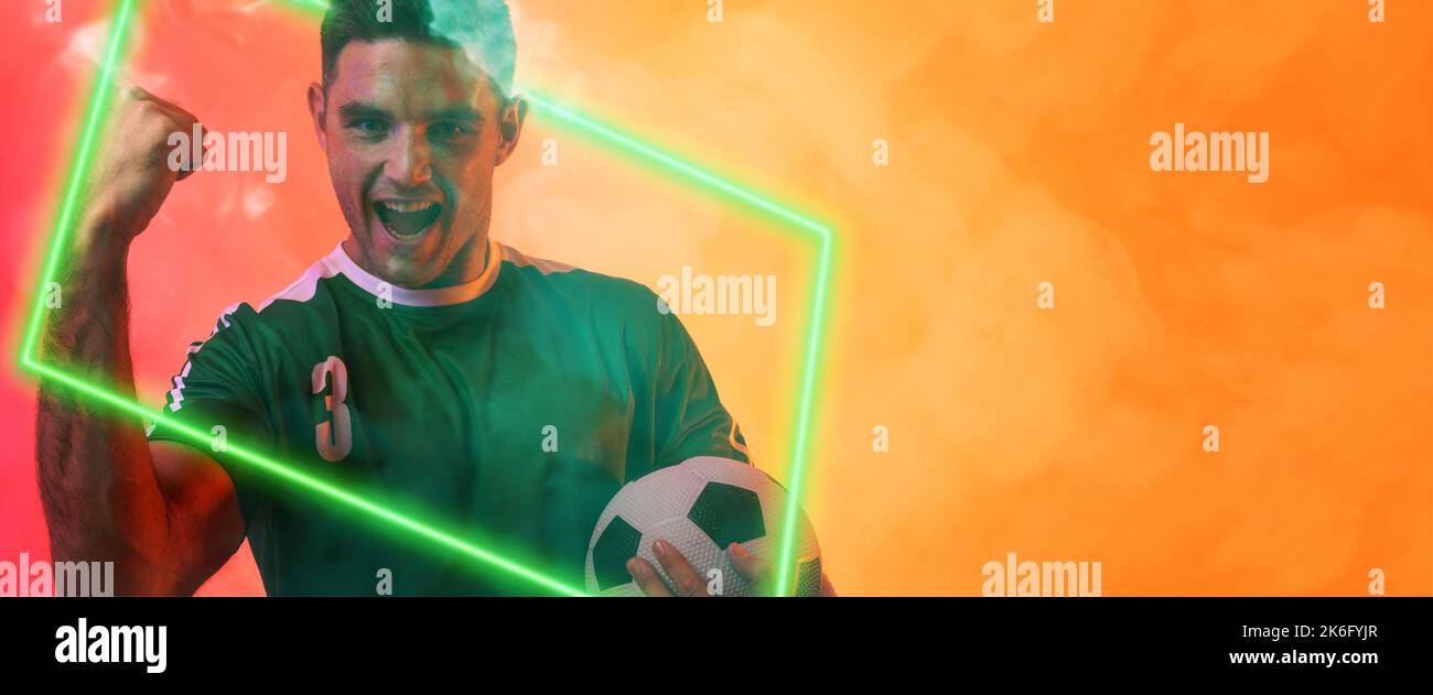 Portrait of happy male caucasian soccer player holding ball and ...