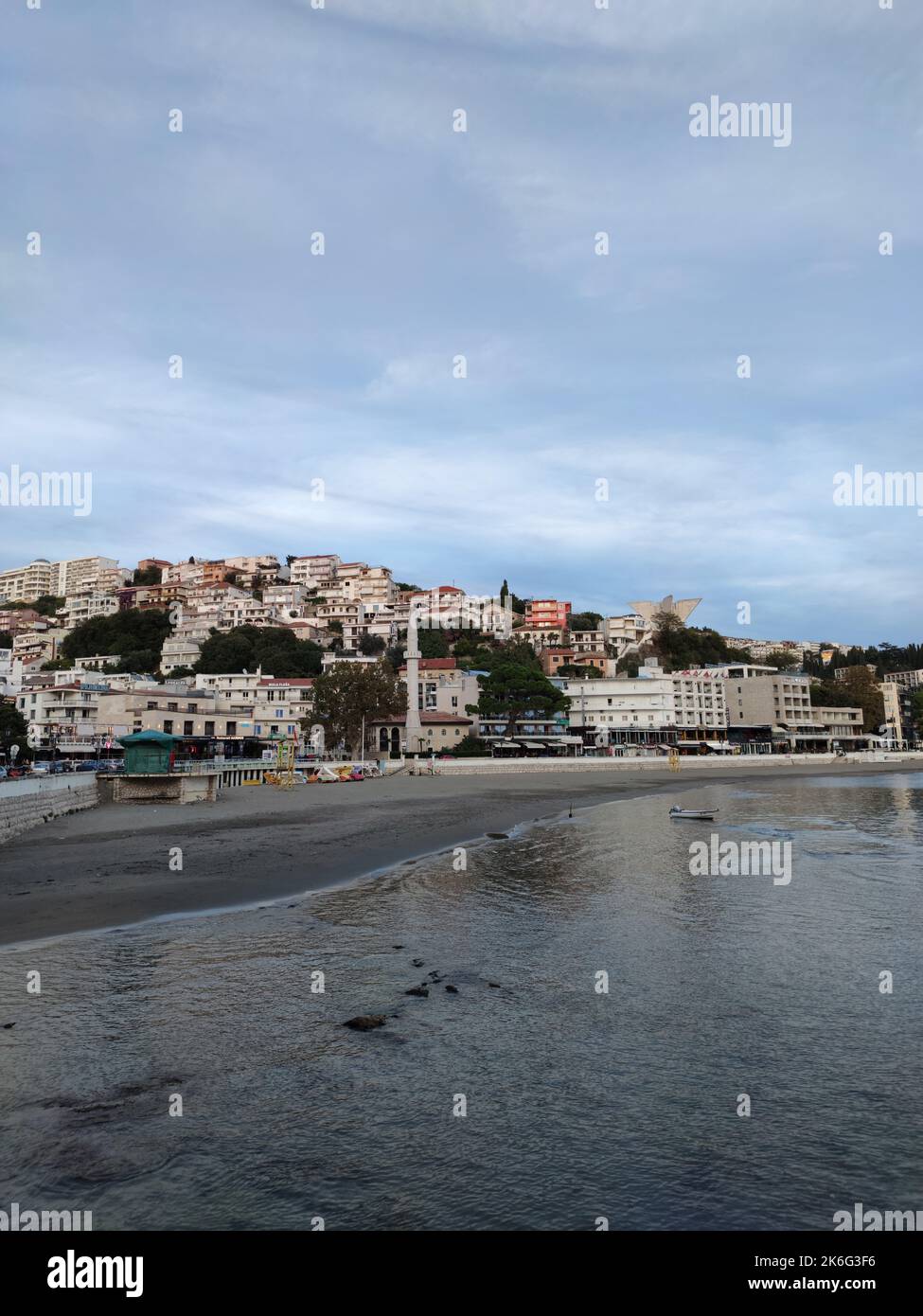 A top view of shallow water by the sandy beach with buildings in the ...