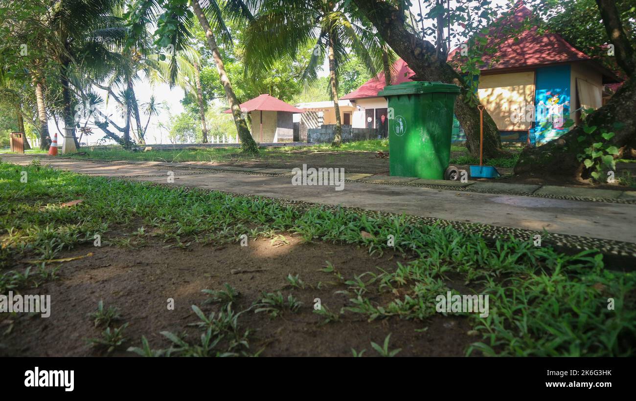green trash can in a tourist place to throw garbage Stock Photo - Alamy