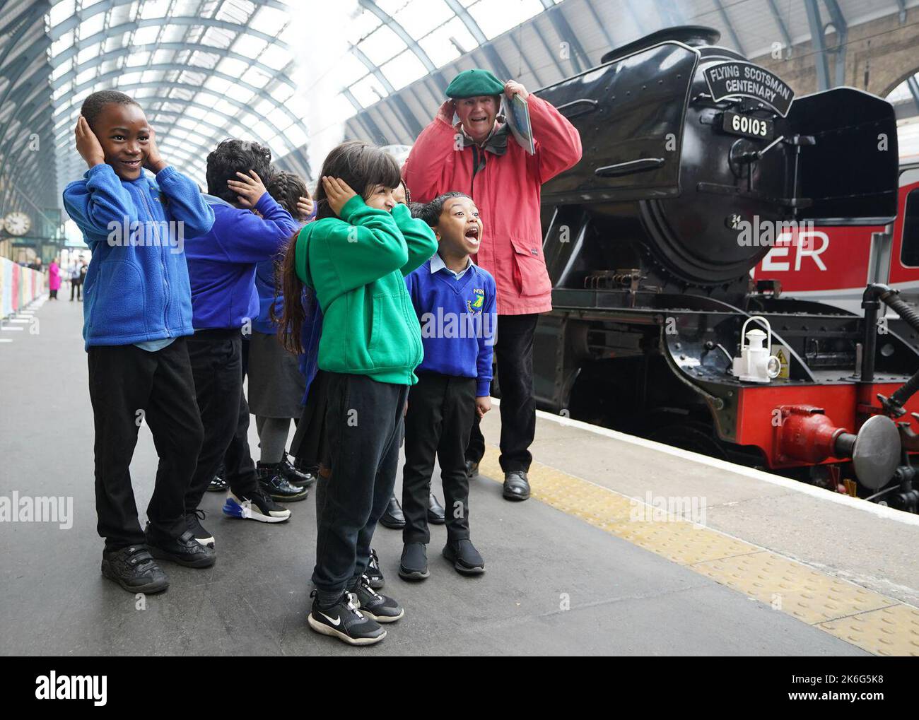 Author Michael Morpurgo gives a reading to school children on Platform 8 at King's Cross Station ...