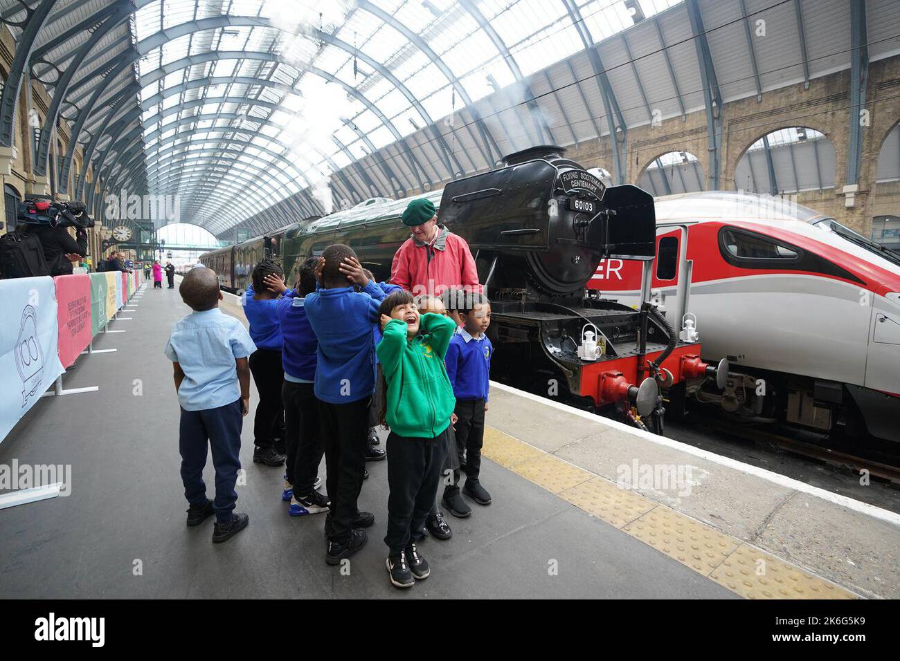 Author Michael Morpurgo gives a reading to school children on Platform 8 at King's Cross Station ...