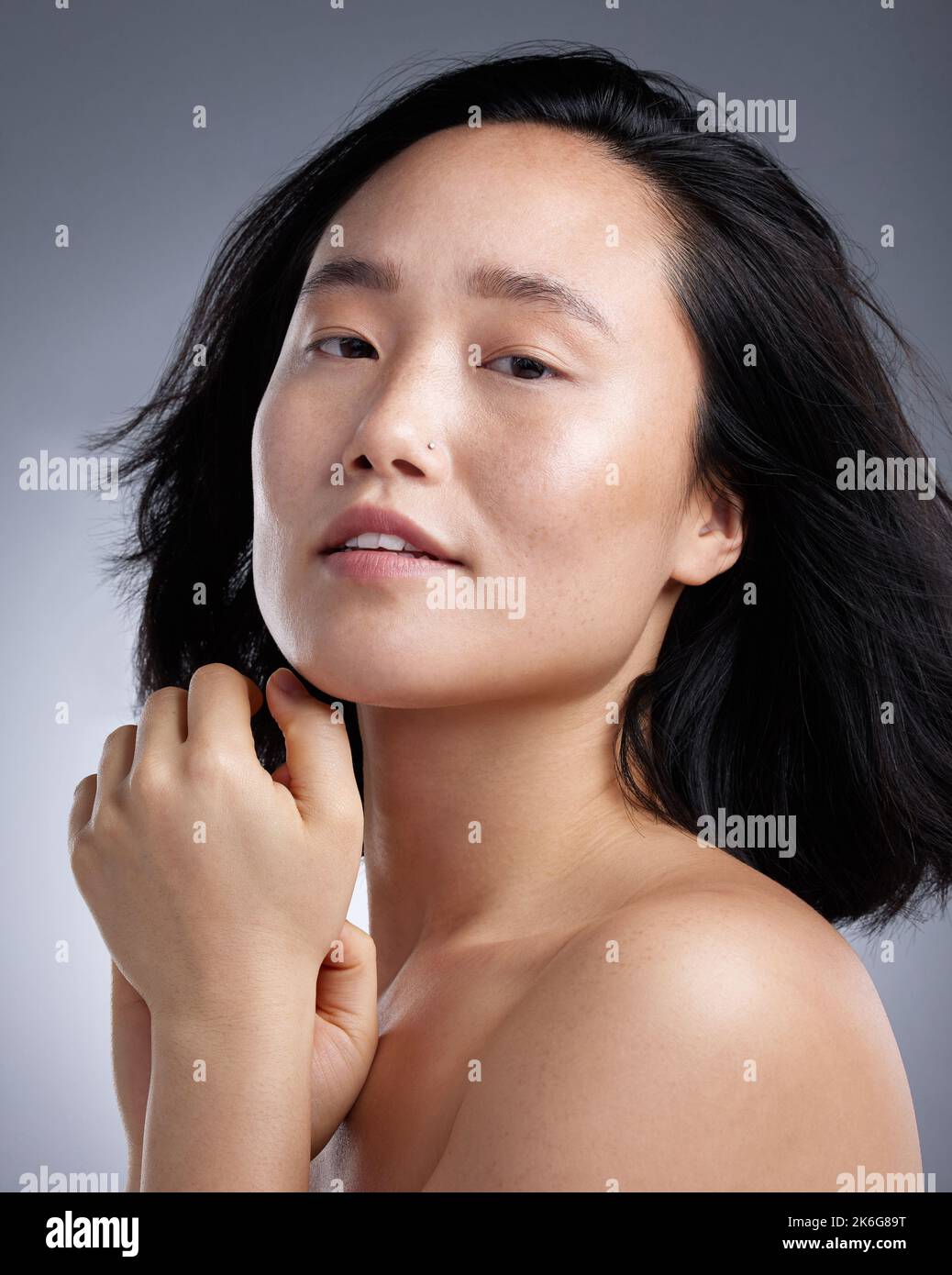 This is my best angle. a young woman standing against a grey background ...