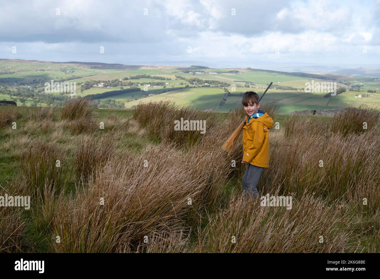 Earl Crag, North Yorkshire, UK. Six year old boy with toy broom ot ...