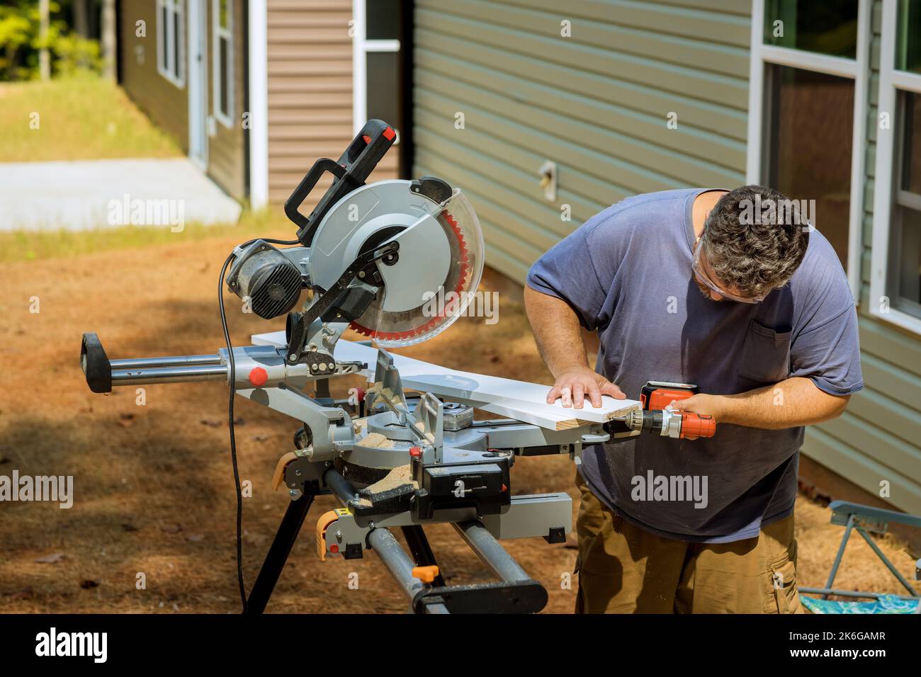 As part construction work carpenter drills holes into wooden boards and ...