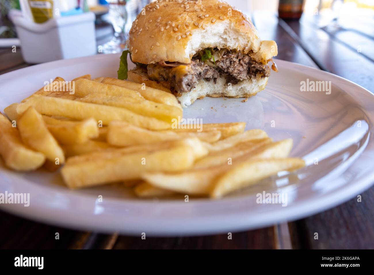 Hamburger sandwich with fries with a huge bite. Delicious junk food ...