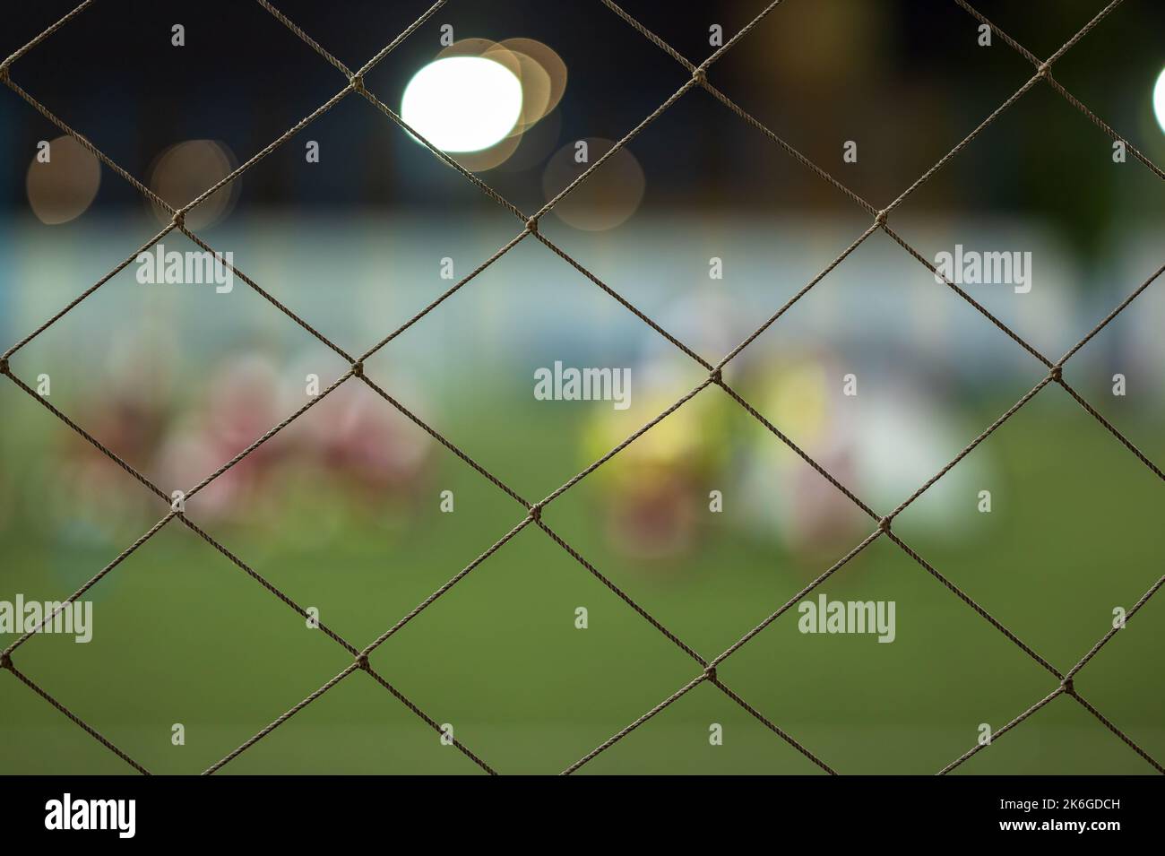 A blurred football net background and players behind the goal with ...