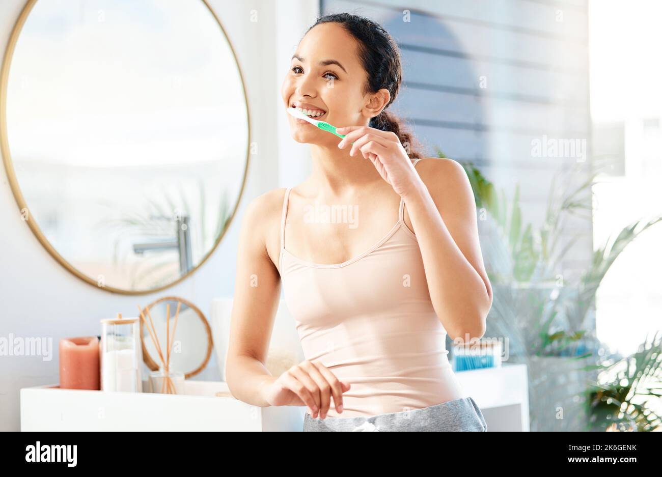 Fresh breath loading. a young woman brushing her teeth at home Stock ...