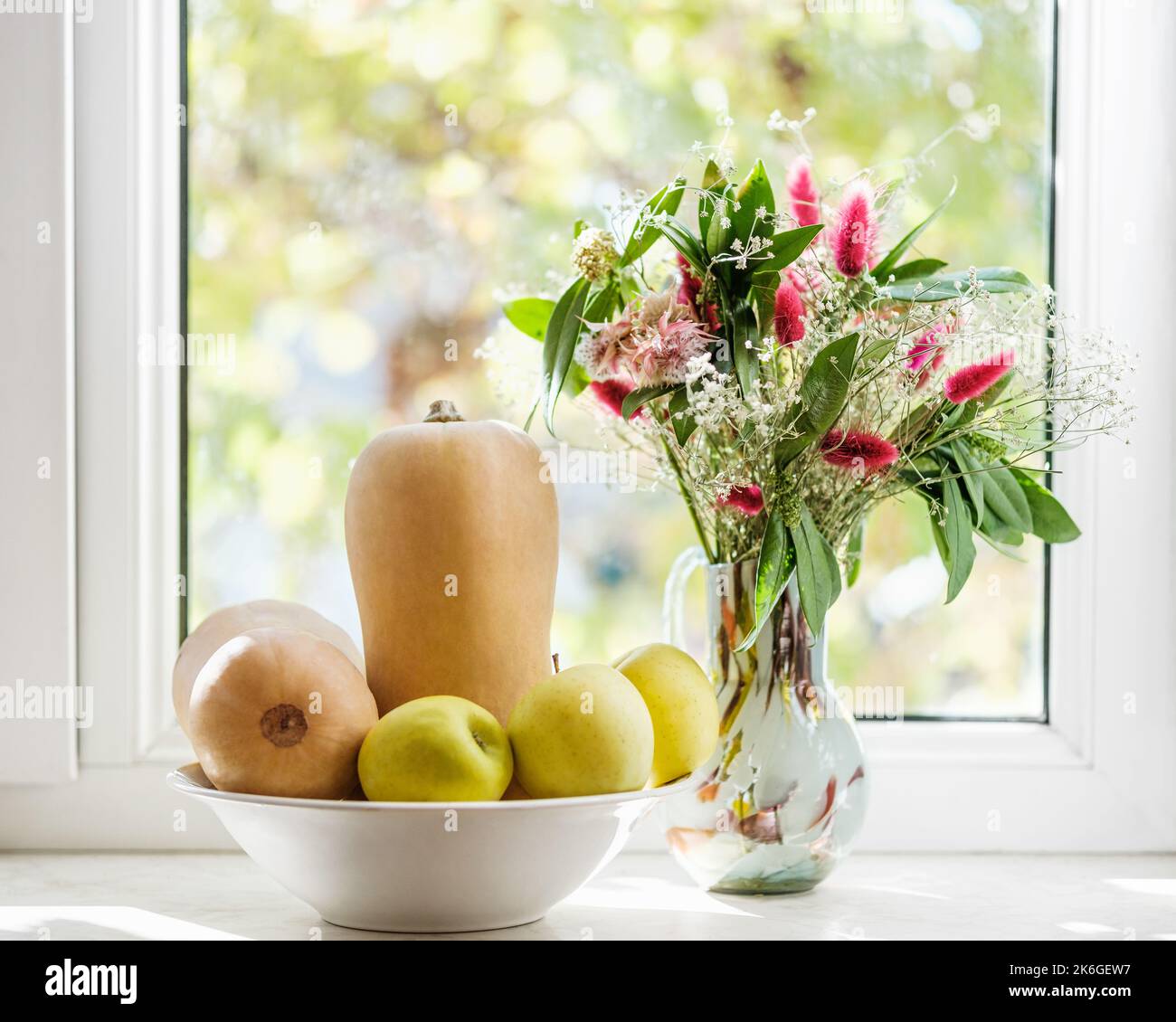 Autumn composition, bouquet of flowers in a vase, butternut squashes ...