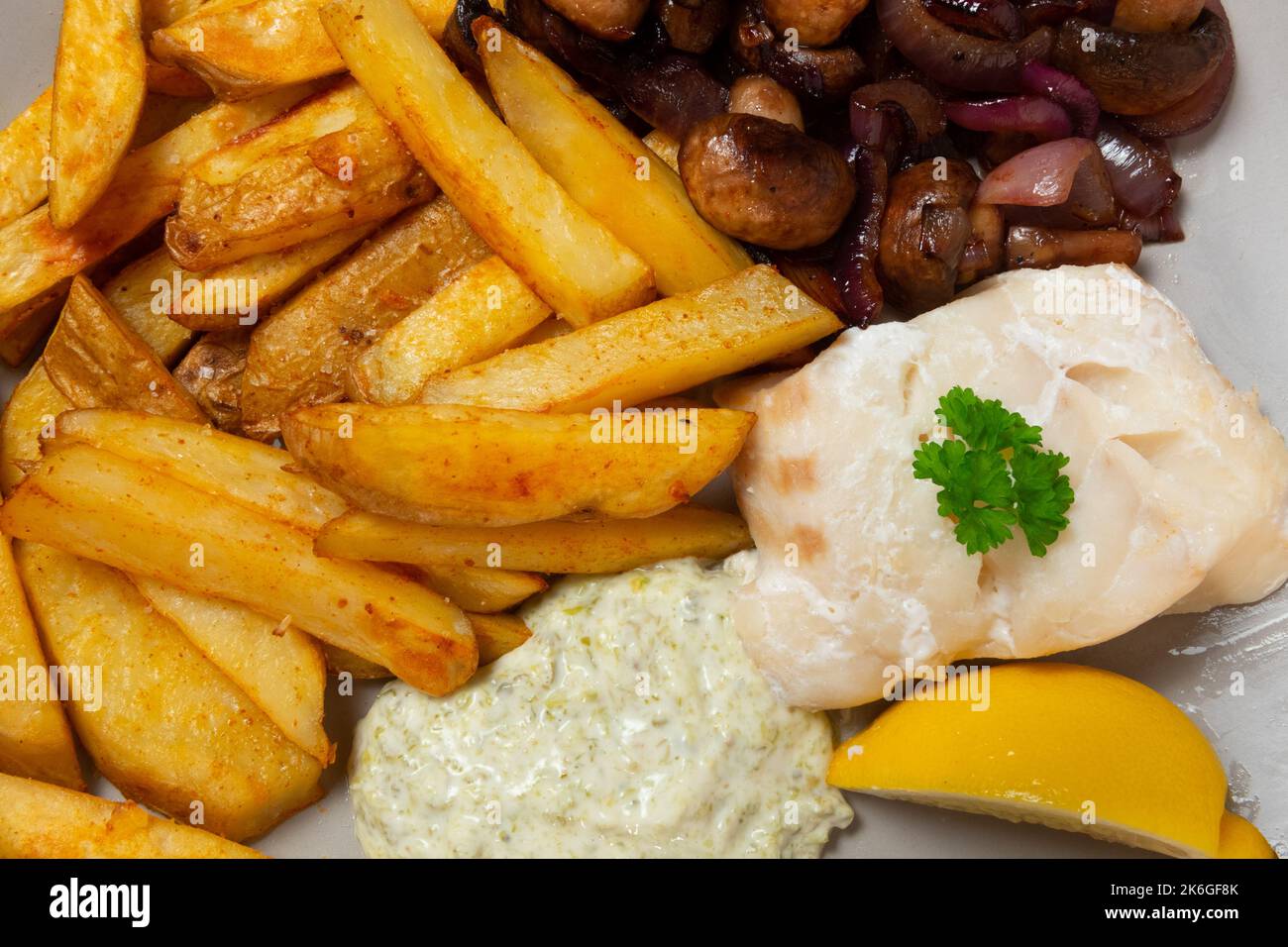 Close up of baked cod loin, skin on chips, sauteed mushroom and red ...