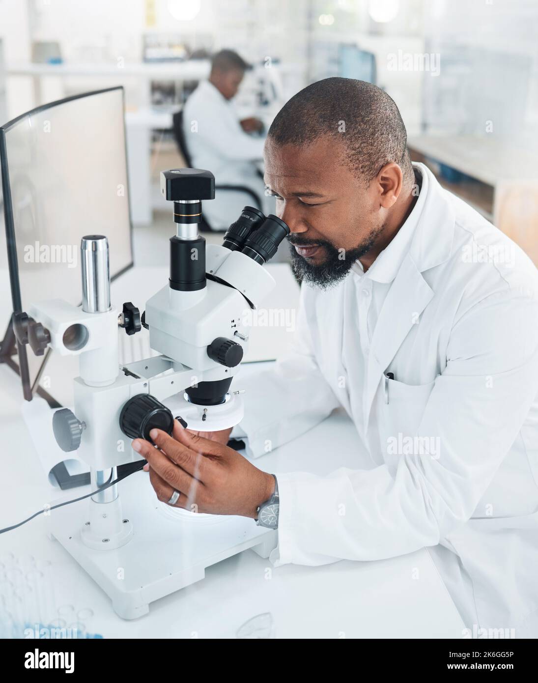 These are ready to undergo a new trial. a mature man using a microscope ...