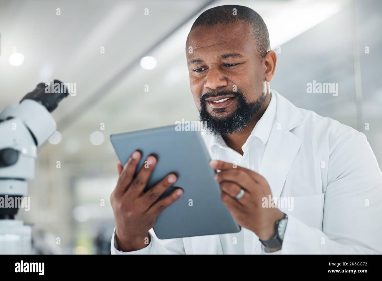 Unpacking a new specimen. a male scientist using a digital tablet while ...
