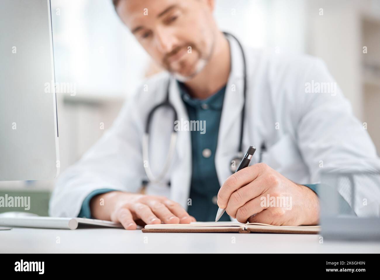 Taking notes to better his diagnosis. Closeup shot of a mature doctor ...