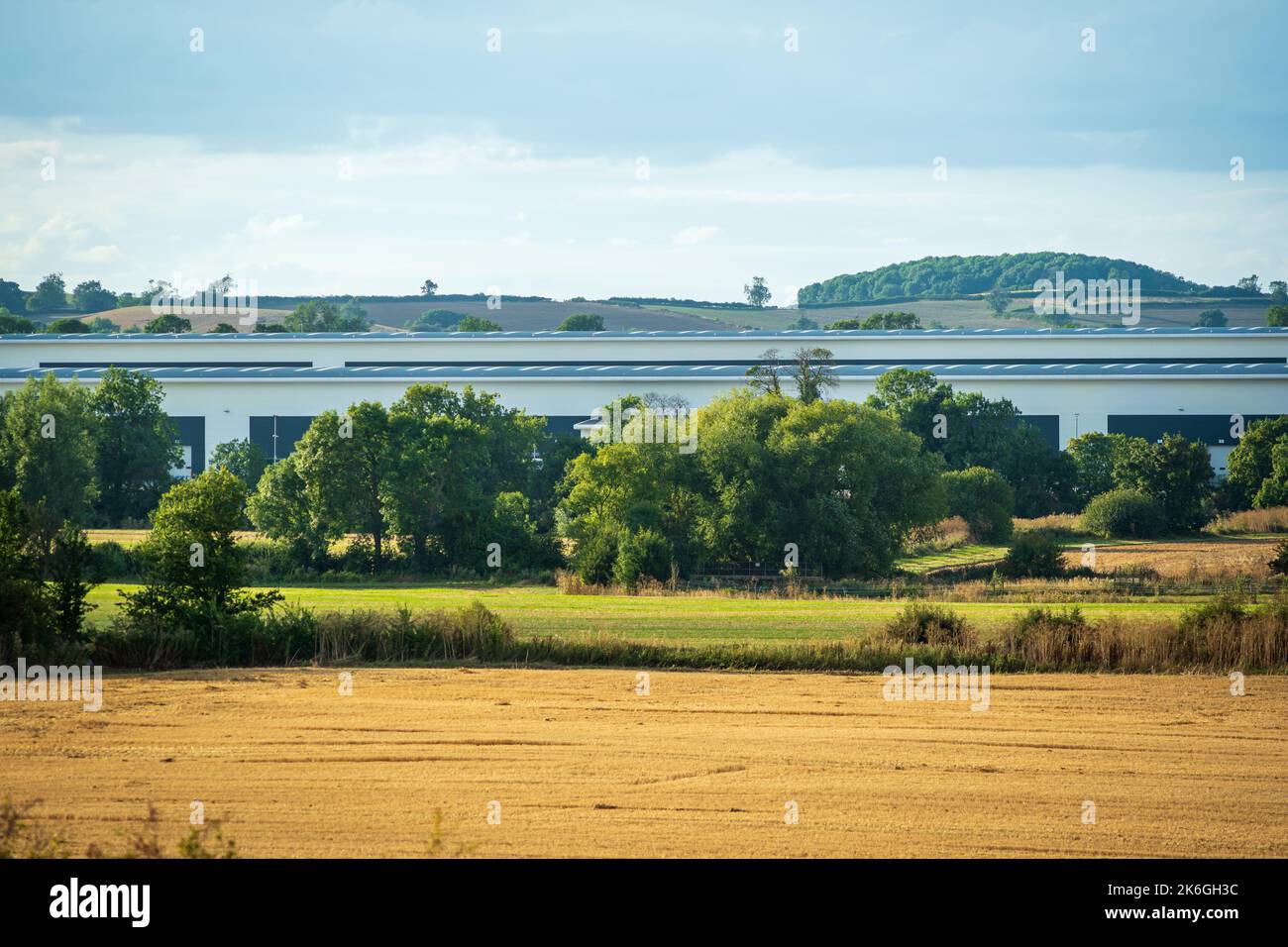 new built distribution warehouse building with farm fields in ...