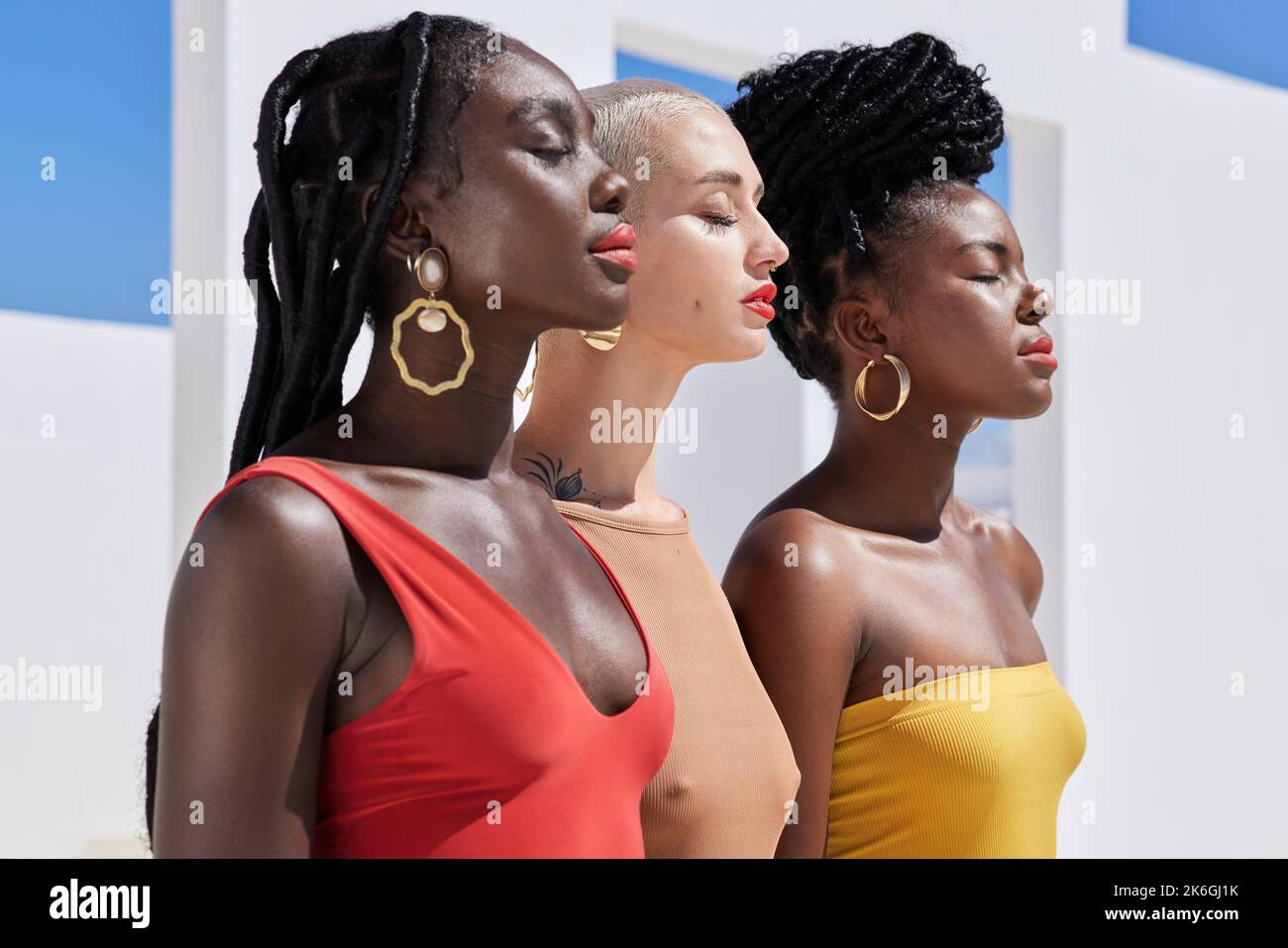Three of a kind. three attractive young women posing on a rooftop outdoors Stock Photo - Alamy
