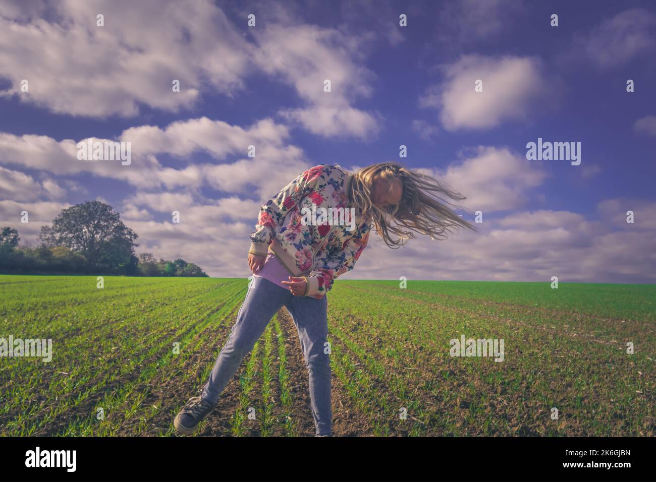 dramatic scene of girl with long blond hair moving in colorful green ...