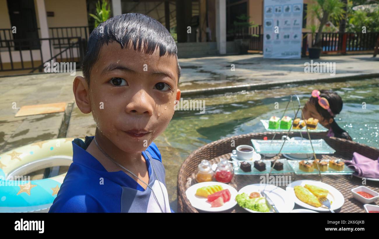 an adorable boy having breakfast floating in the pool Stock Photo - Alamy