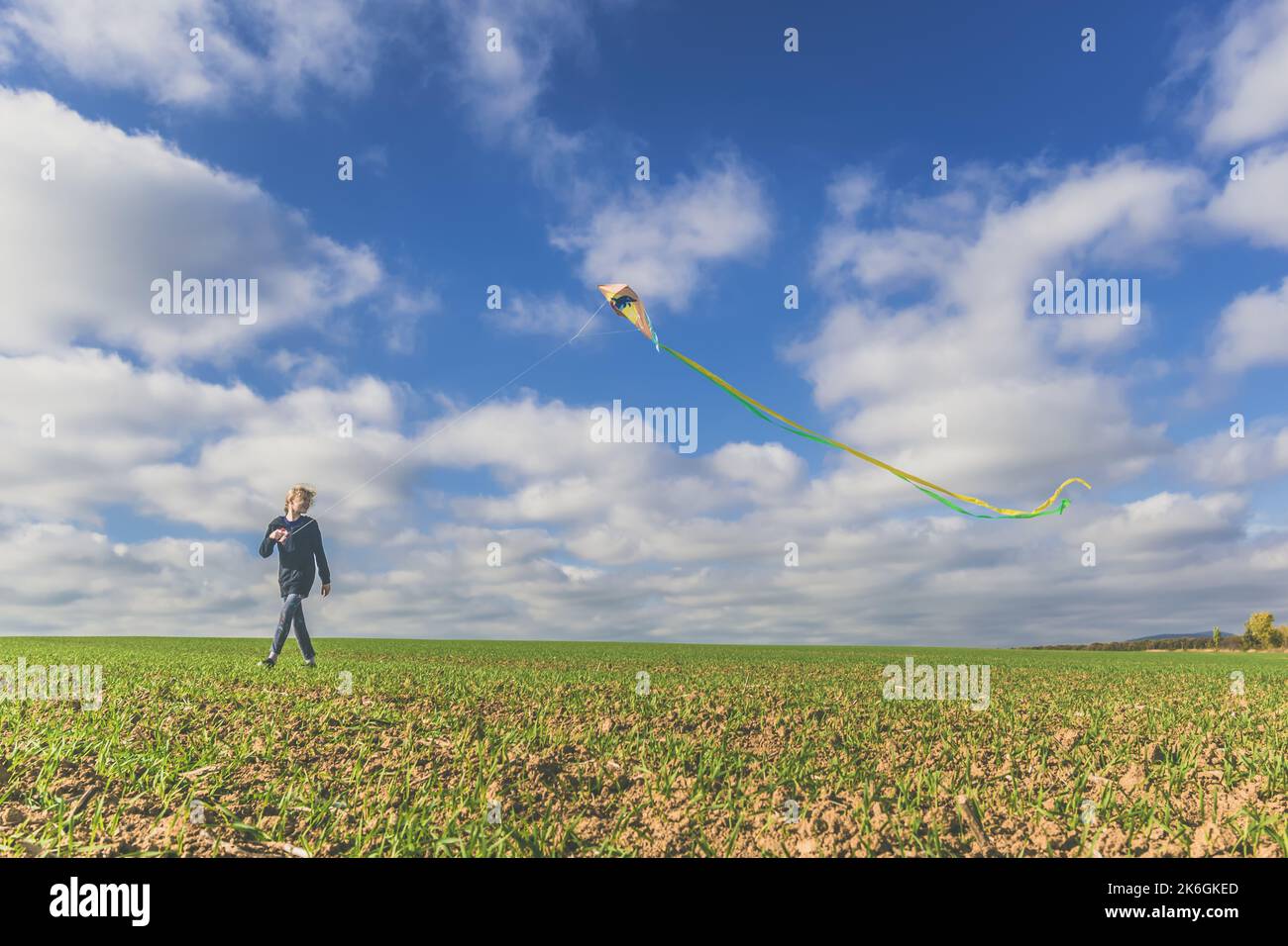 cute girl running with kite in green field in sunny autumnal day Stock ...