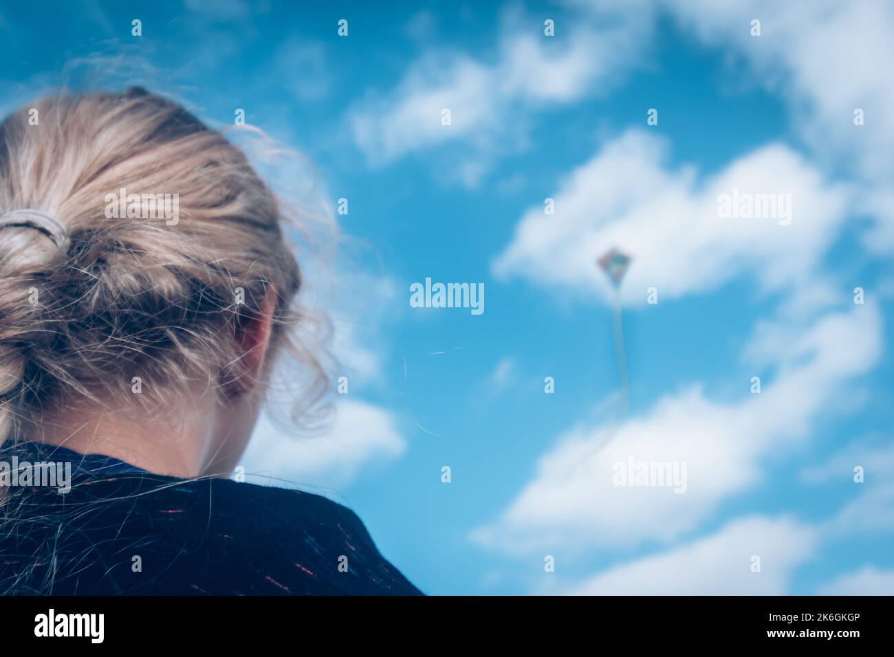 close up of girls head back view managing a kite in the sky Stock Photo ...