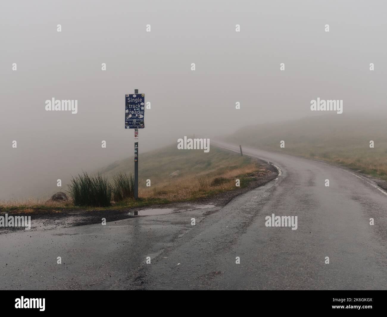 A passing place highland mountain narrow road sign shrouded in low ...