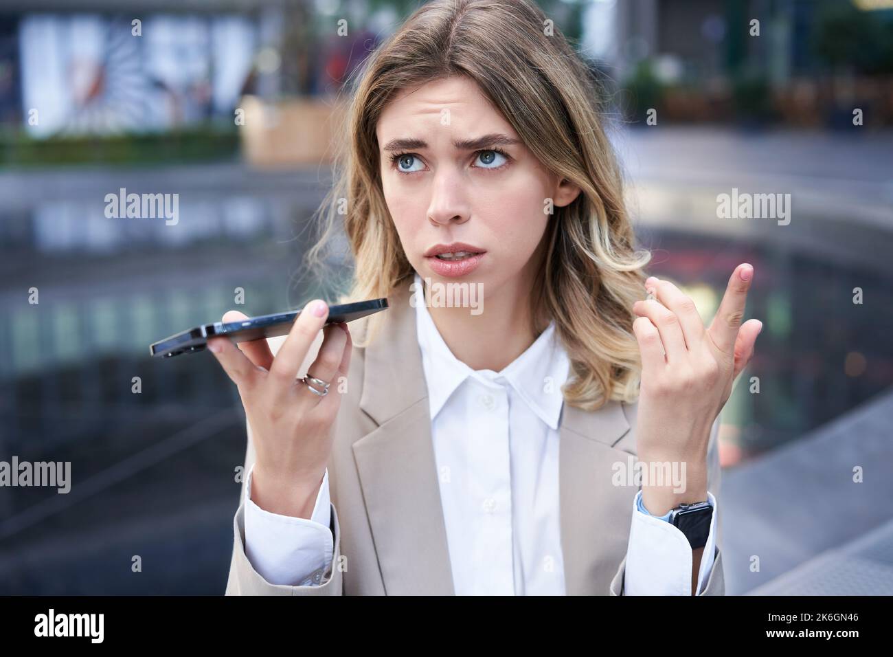 Portrait of confused businesswoman recording voice message, counting ...