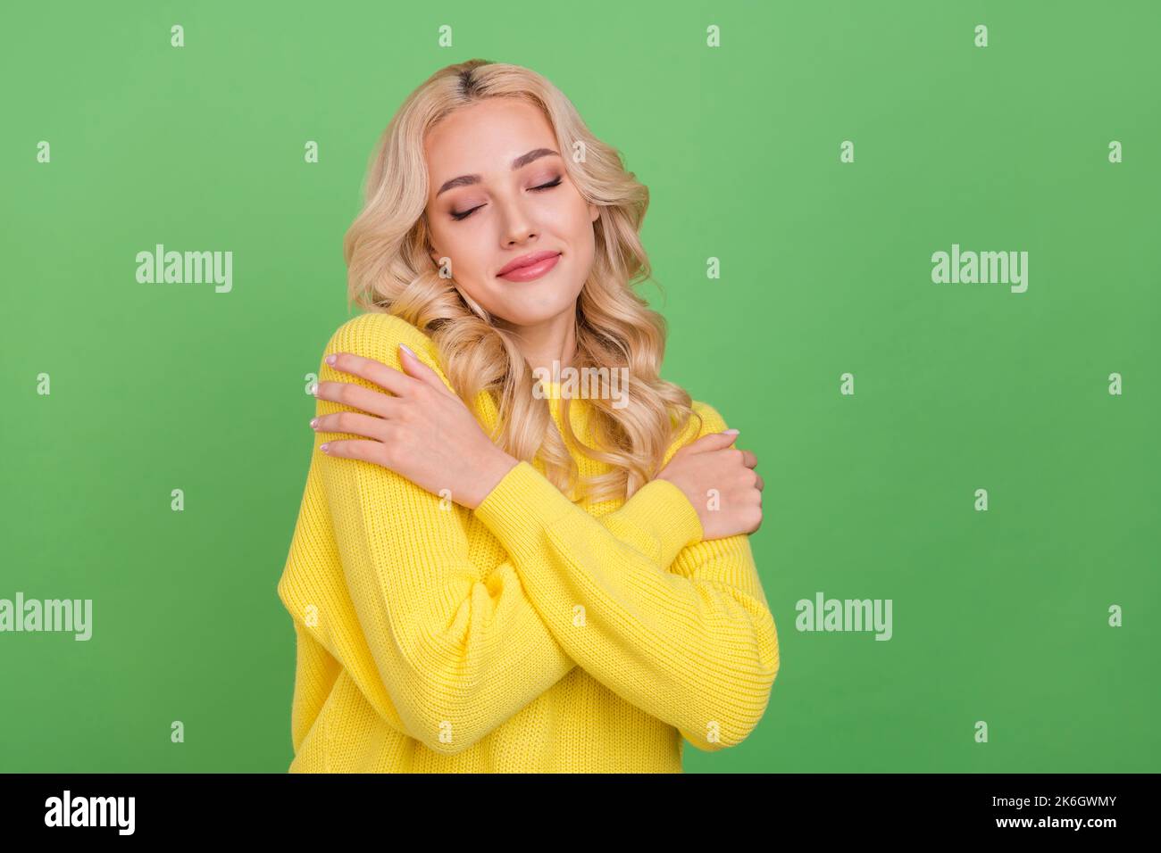 Photo Of Cute Millennial Blond Lady Hug Herself Wear Yellow Pullover