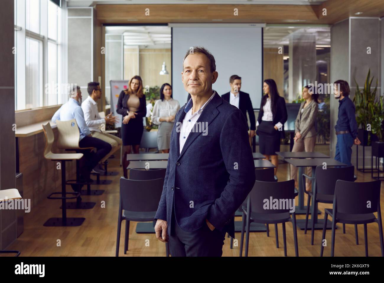 Successful adult Caucasian man manager in meeting room in front of ...