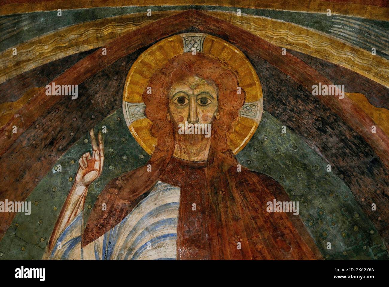 Black-eyed Jesus, thick red hair framed by a golden halo, raises his ...