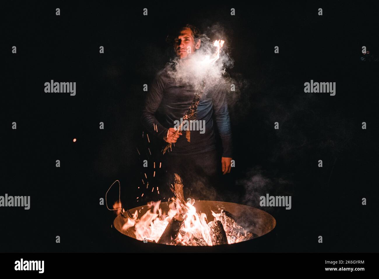 bonfire burning inside a large metal container and caucasian boy ...